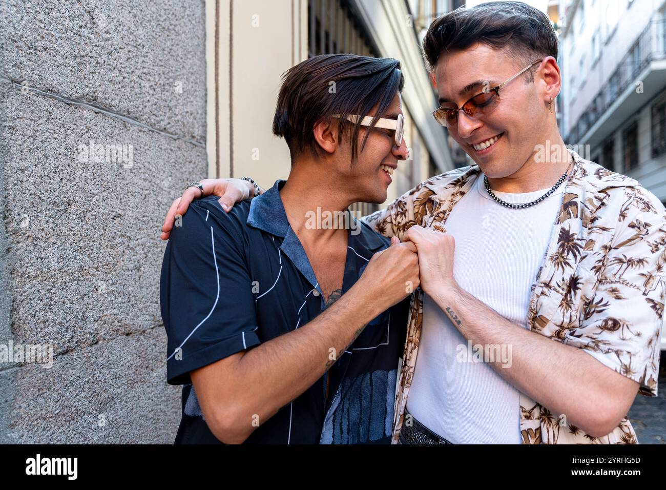 Two stylish young gay men share a joyful, playful moment together while ...