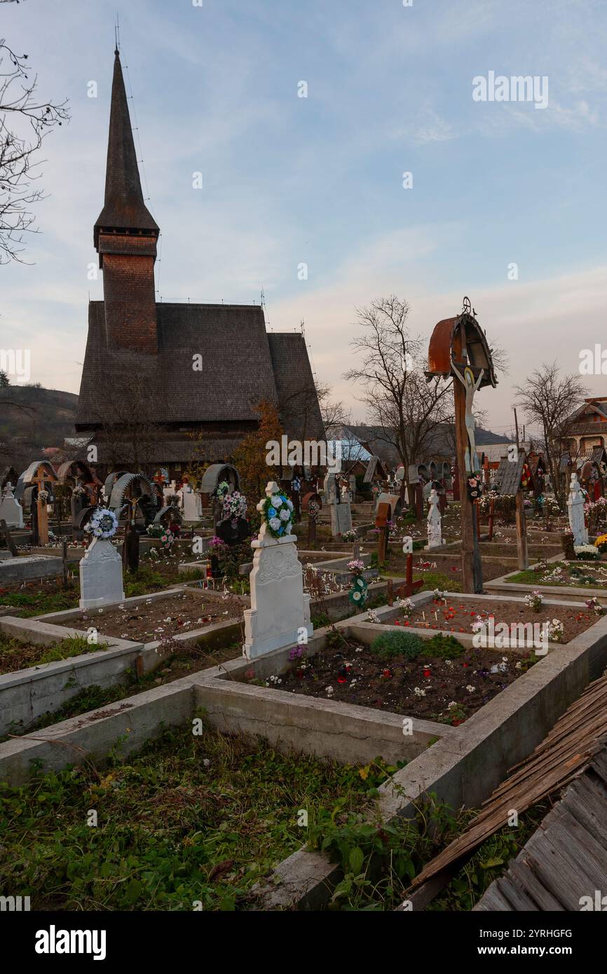 A picturesque view of a traditional church and cemetery in Maramures ...