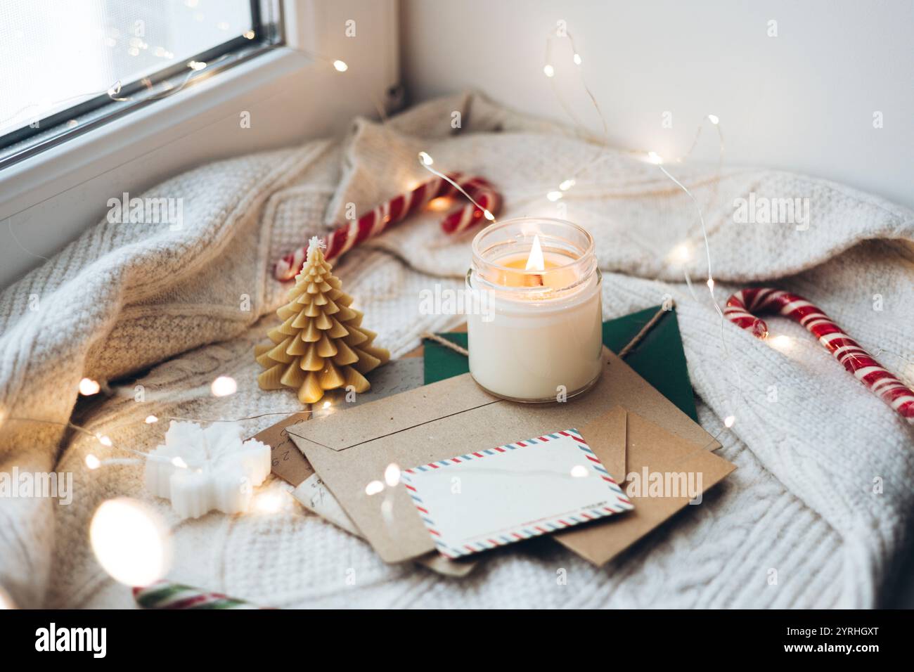 Warm Christmas scene by a window with a glowing candle, festive ...