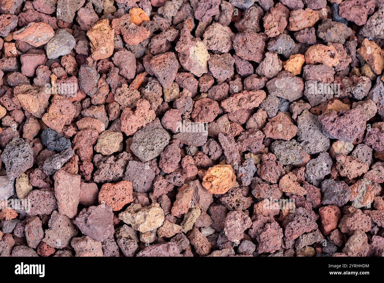 A detailed view of volcanic gravel showcasing its vibrant colors and ...
