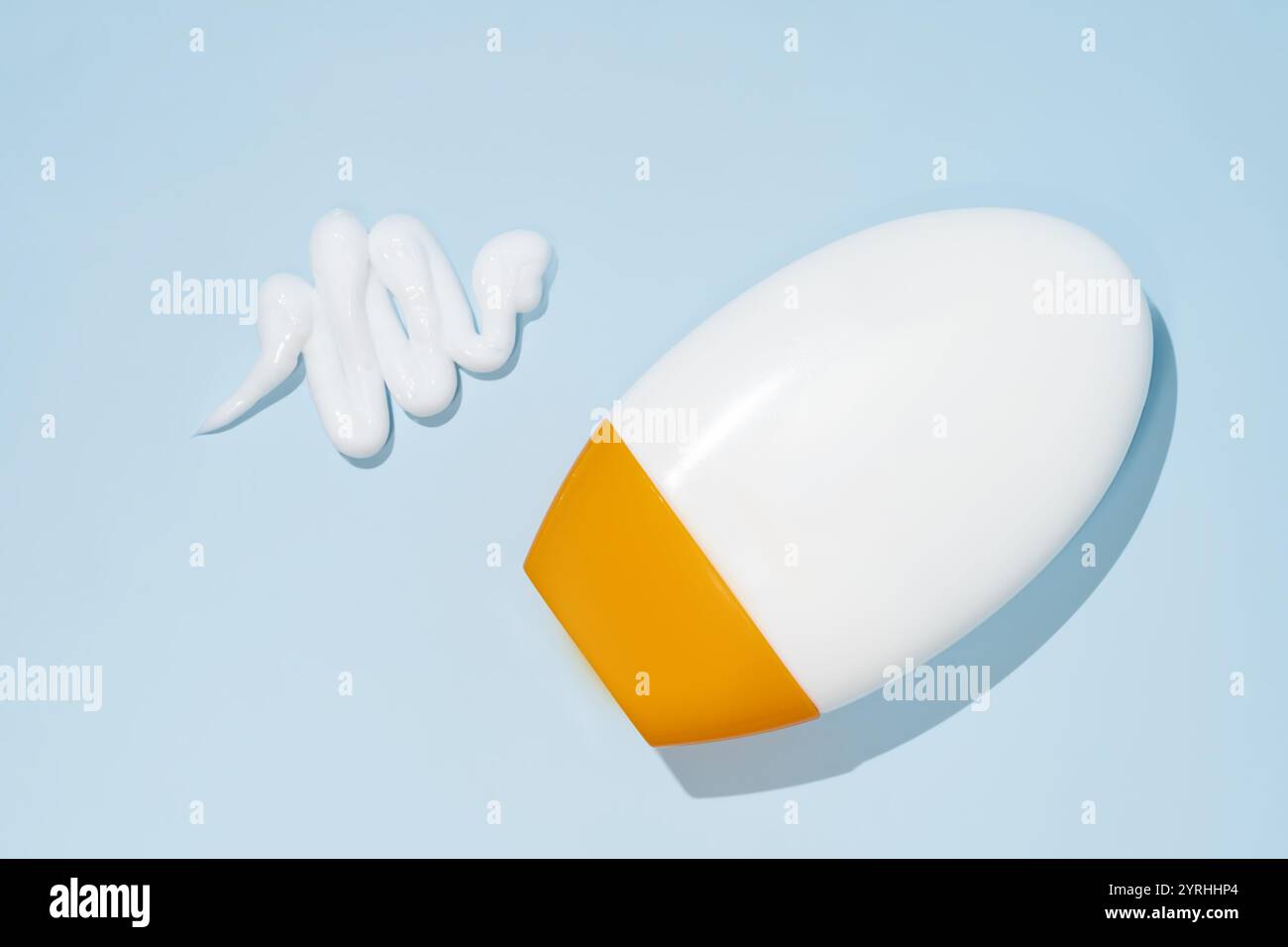 Sun protection cream in a sleek white and yellow package on a pastel ...