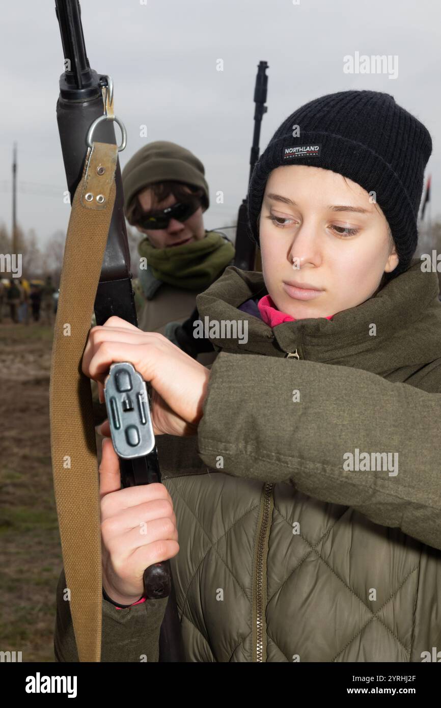 A girl is seen loading a Kalashnikov rifle during a military exercise ...