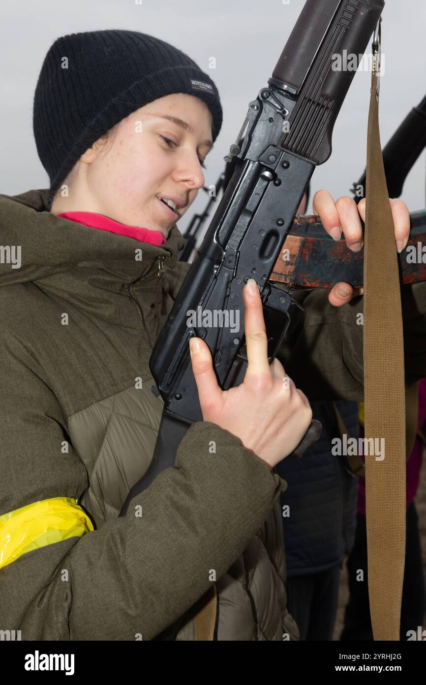 A girl is seen loading a Kalashnikov rifle during a military exercise ...