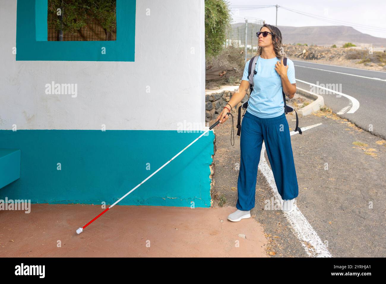 A determined woman navigates her urban environment with a cane ...