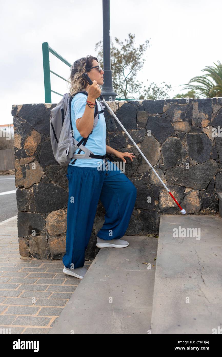 A woman navigates urban steps with a white cane, demonstrating daily ...