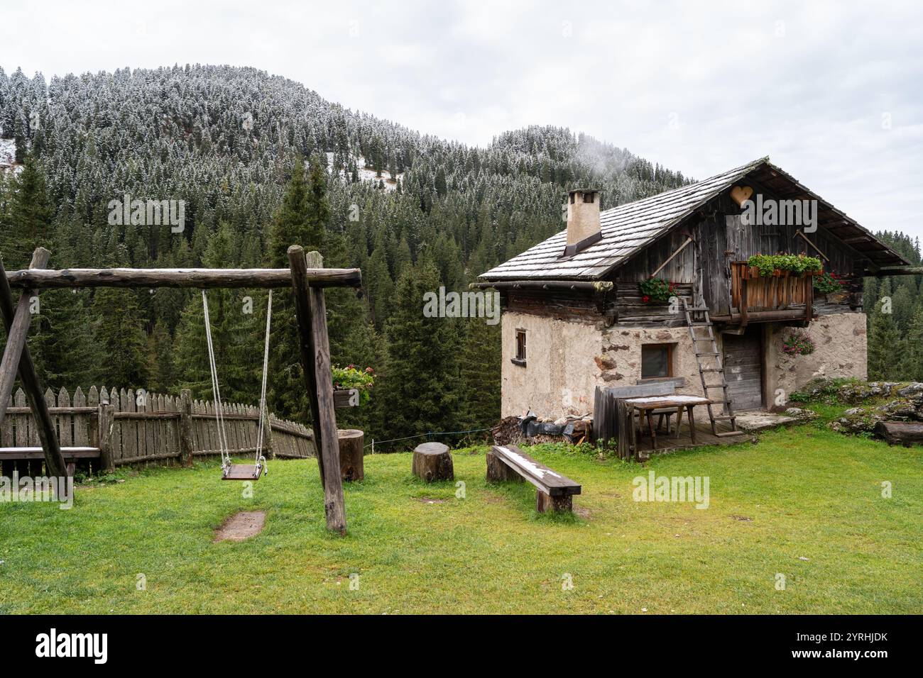 A rustic cabin with a wooden swing set in the serene natural setting of ...
