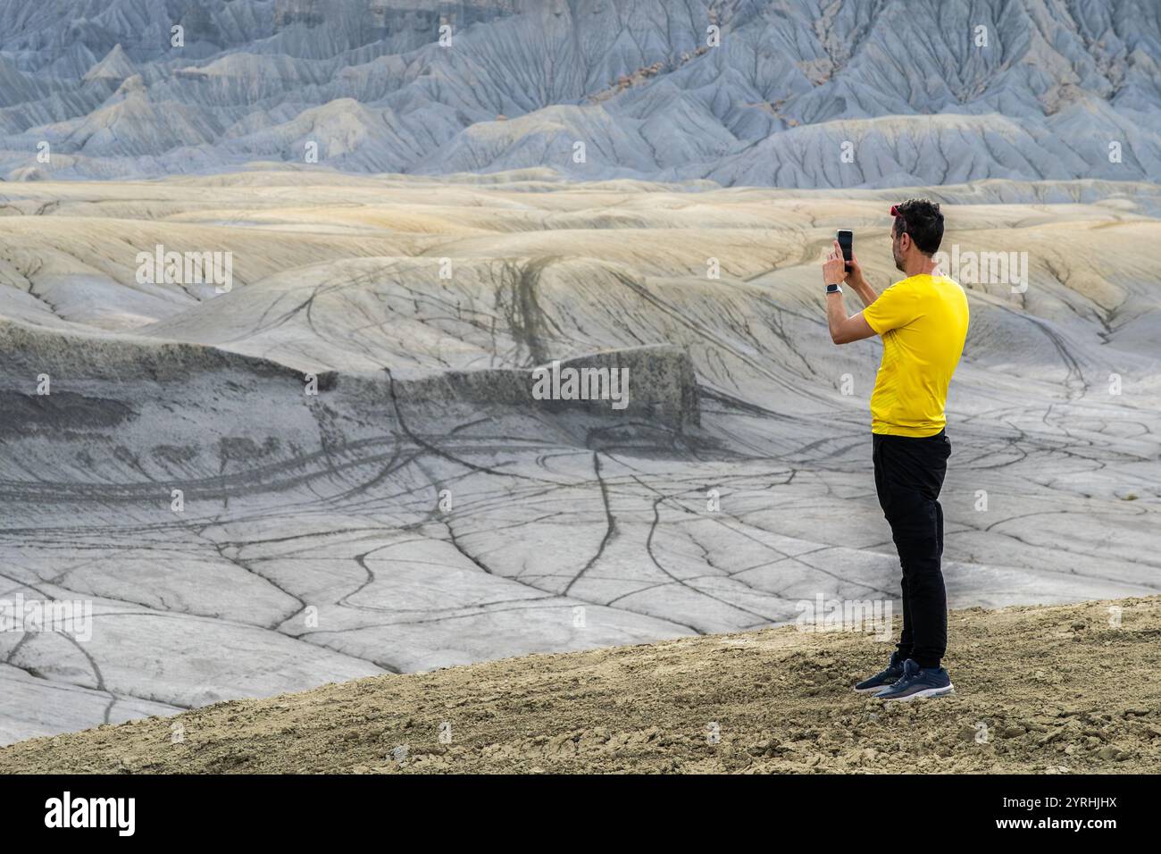 A person in vibrant attire photographs the stunning and rugged ...