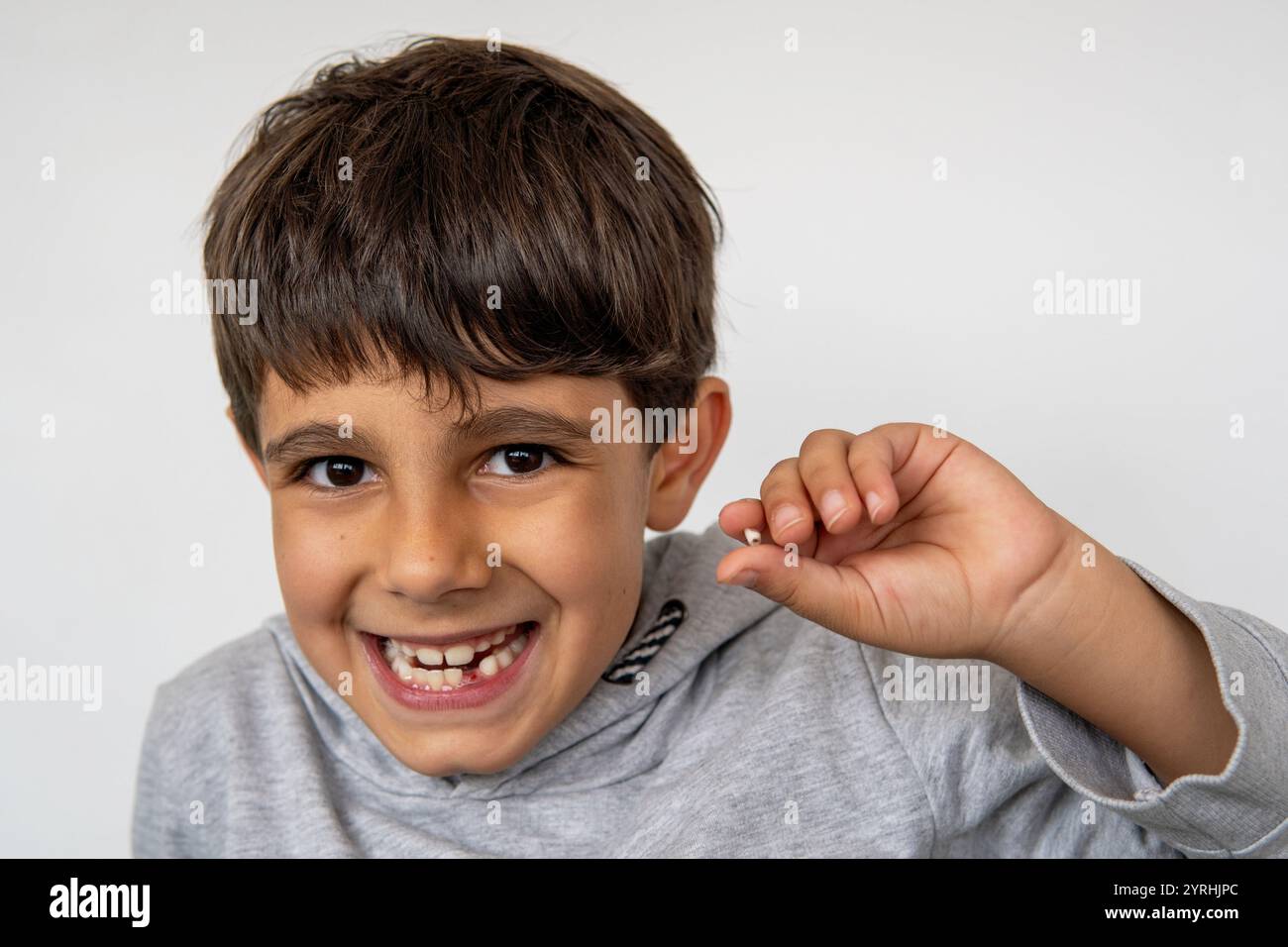 A joyful child holding a lost baby tooth, smiling widely This moment ...