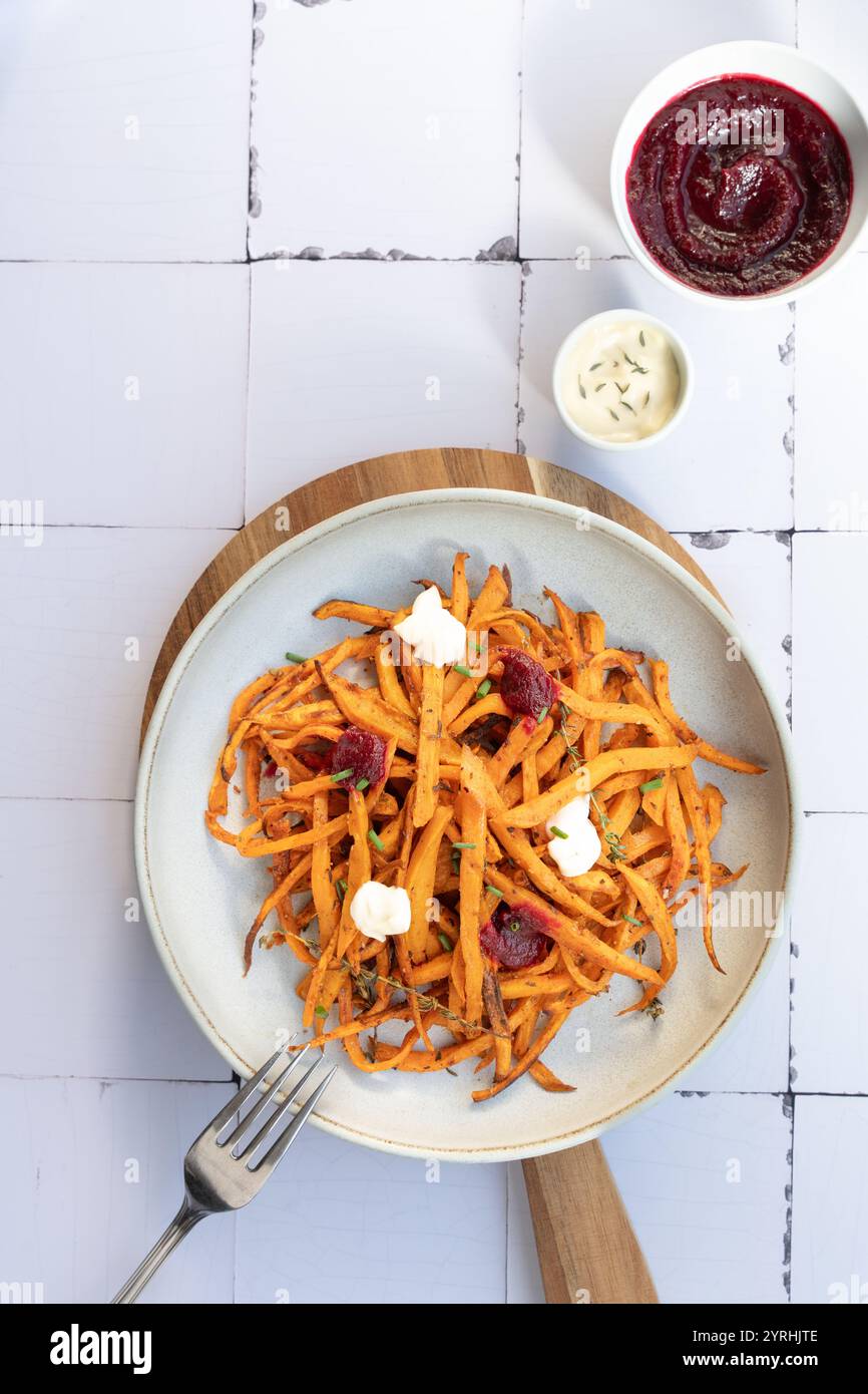 Crispy baked sweet potato sticks seasoned with spices, served with ...