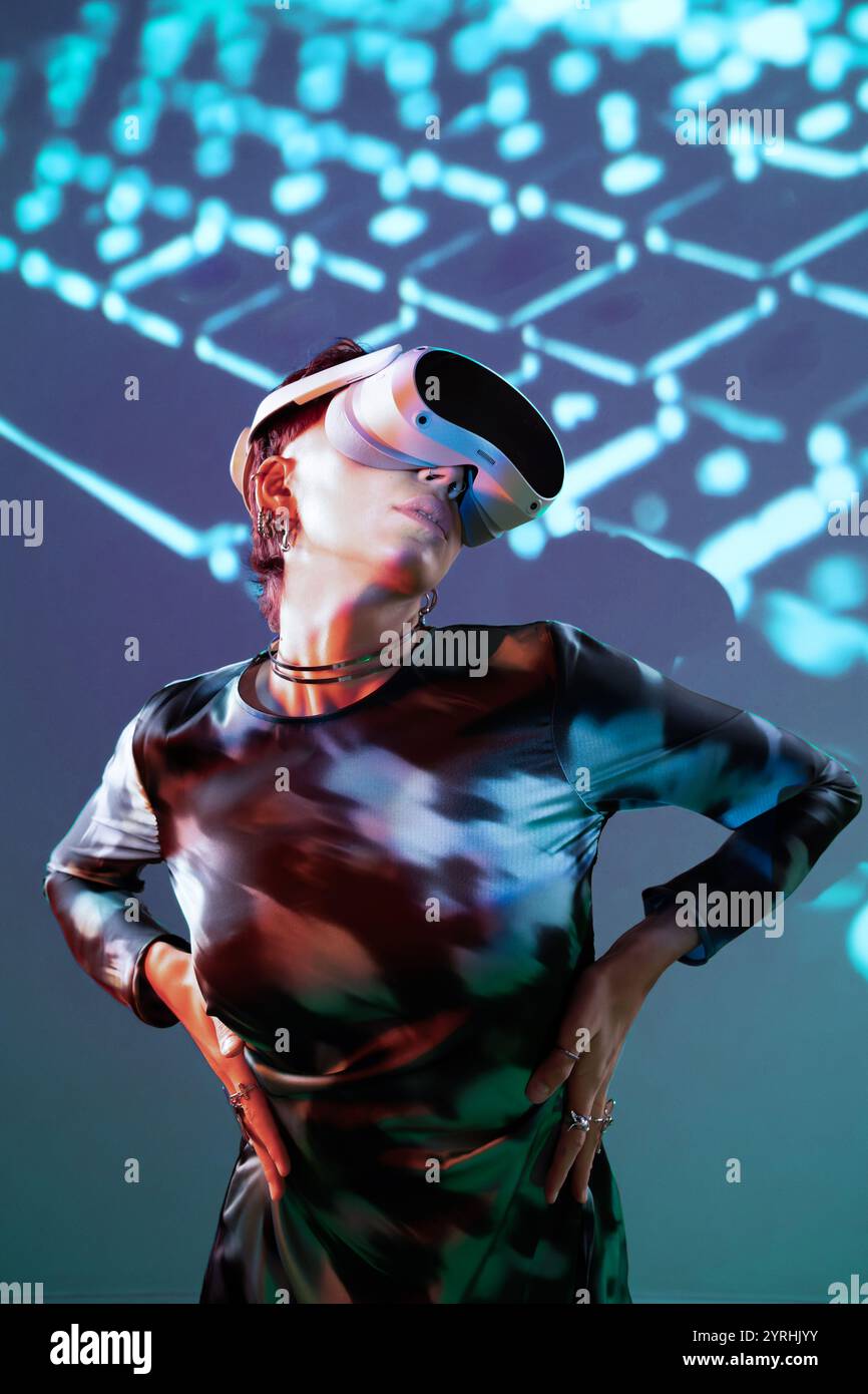 A woman wearing a VR headset stands enigmatically with illuminated digital patterns casting over ...