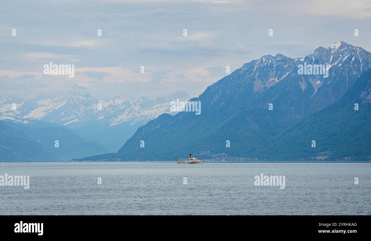 Tranquil view of Lake Geneva with a vintage steamboat set against the ...