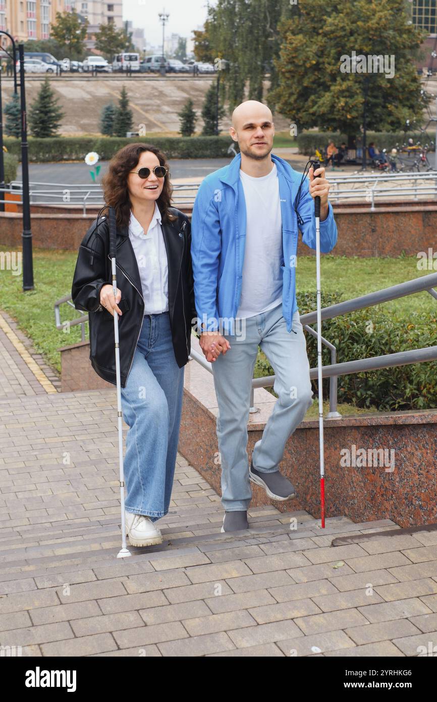 A blind couple with visual impairments uses walking canes while ...