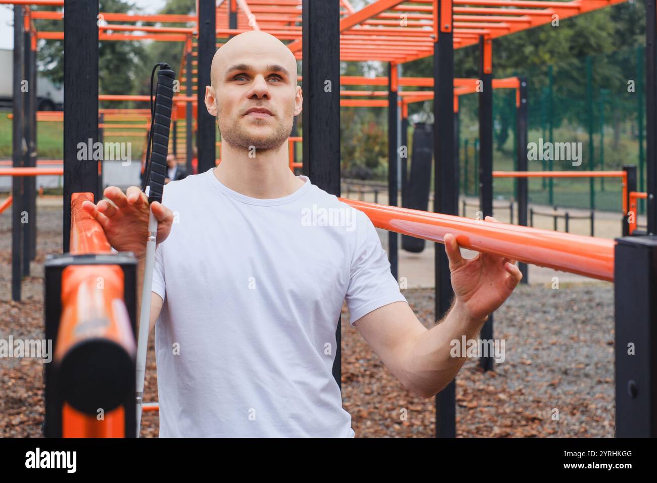 A visually impaired blind man confidently navigates an outdoor fitness ...
