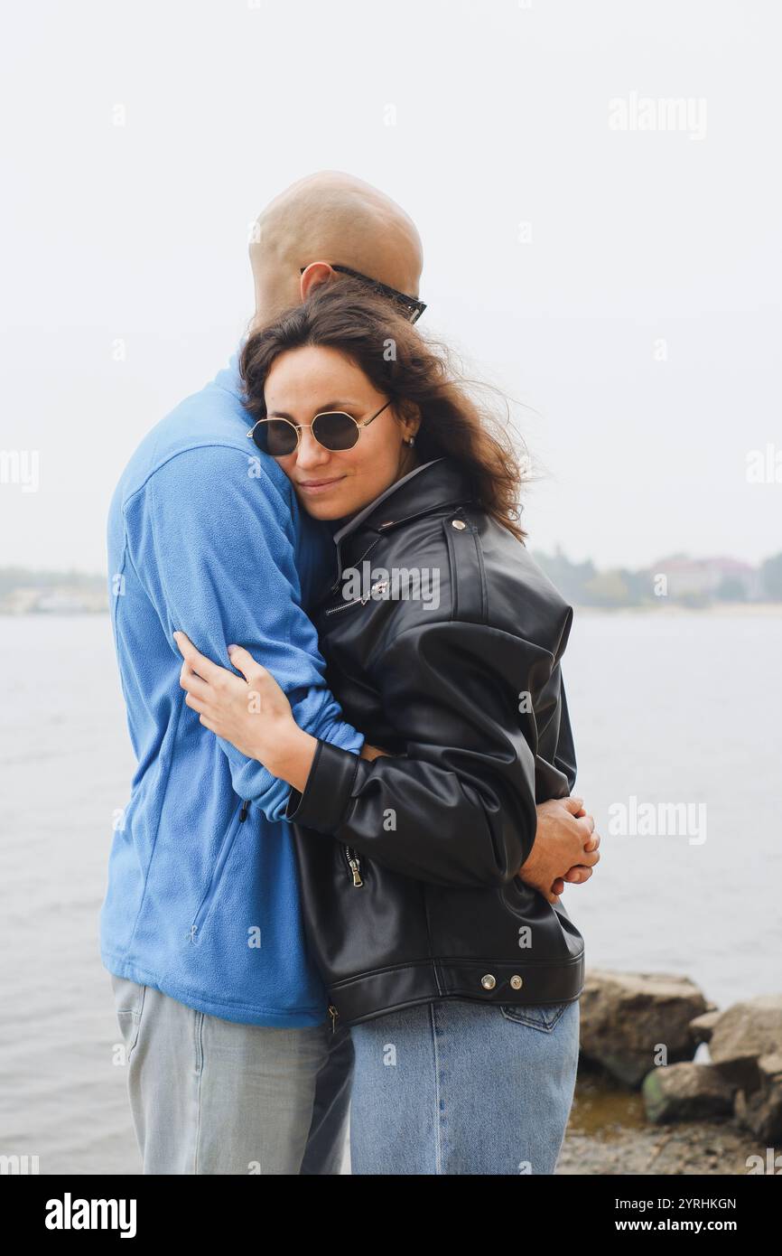 A blind couple shares a tender embrace by a tranquil lakeside. The ...