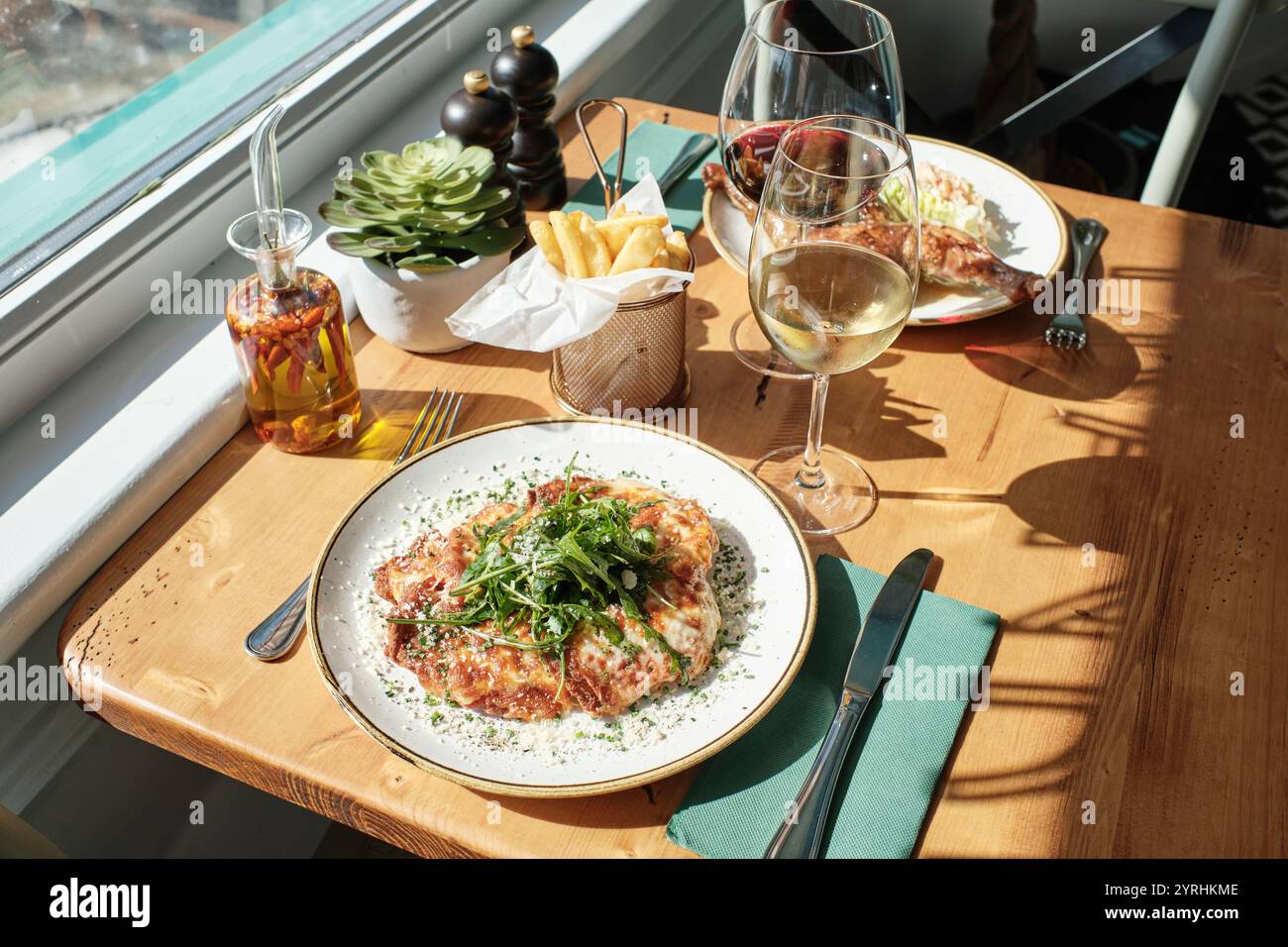 A cozy table setup featuring gourmet snacks and wine glasses Sunlight ...