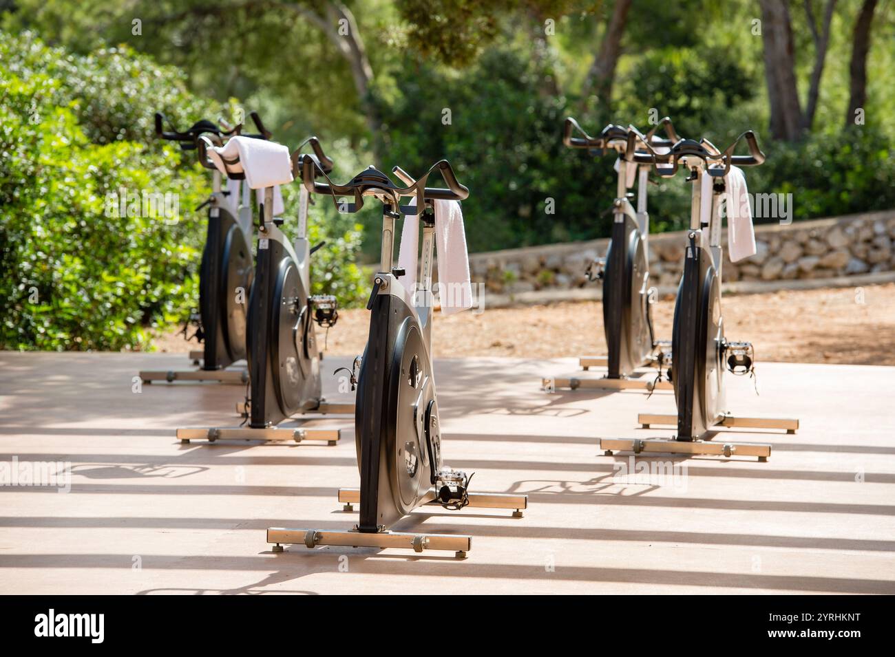 Row of stationary bikes set up in an outdoor fitness space surrounded ...