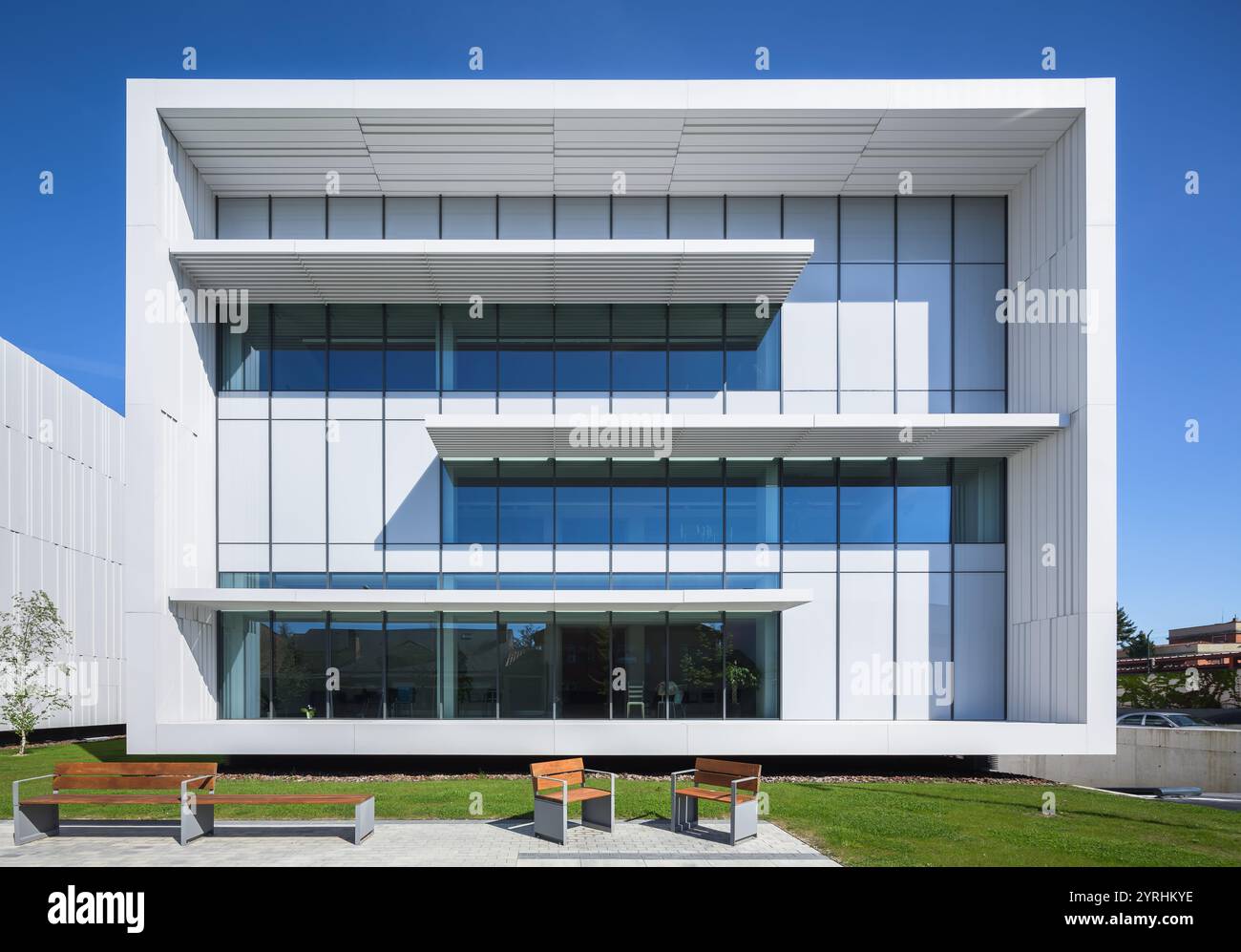 A contemporary hospital center features a sleek, angular facade with ...