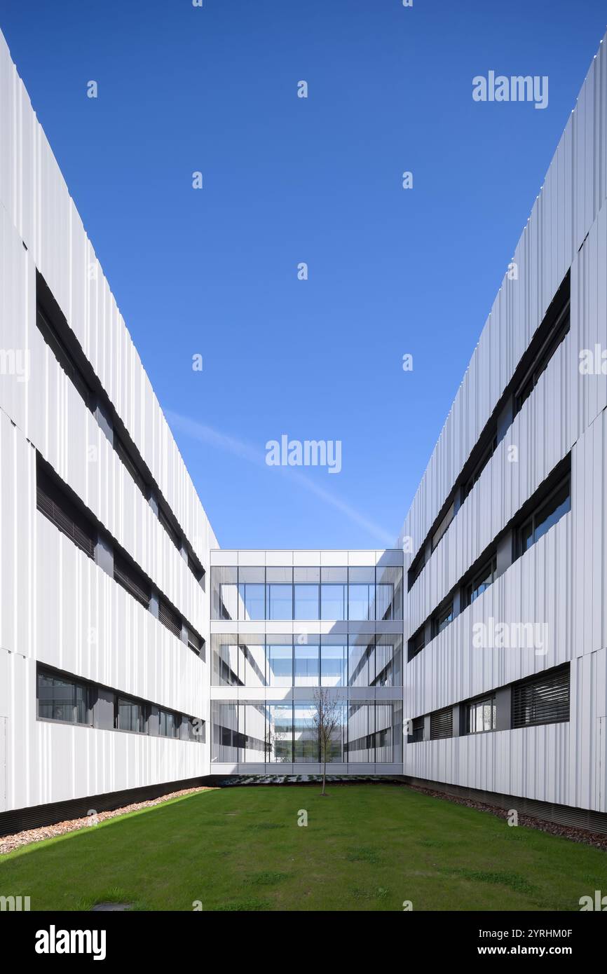 A contemporary hospital building showcases sleek white facades and ...