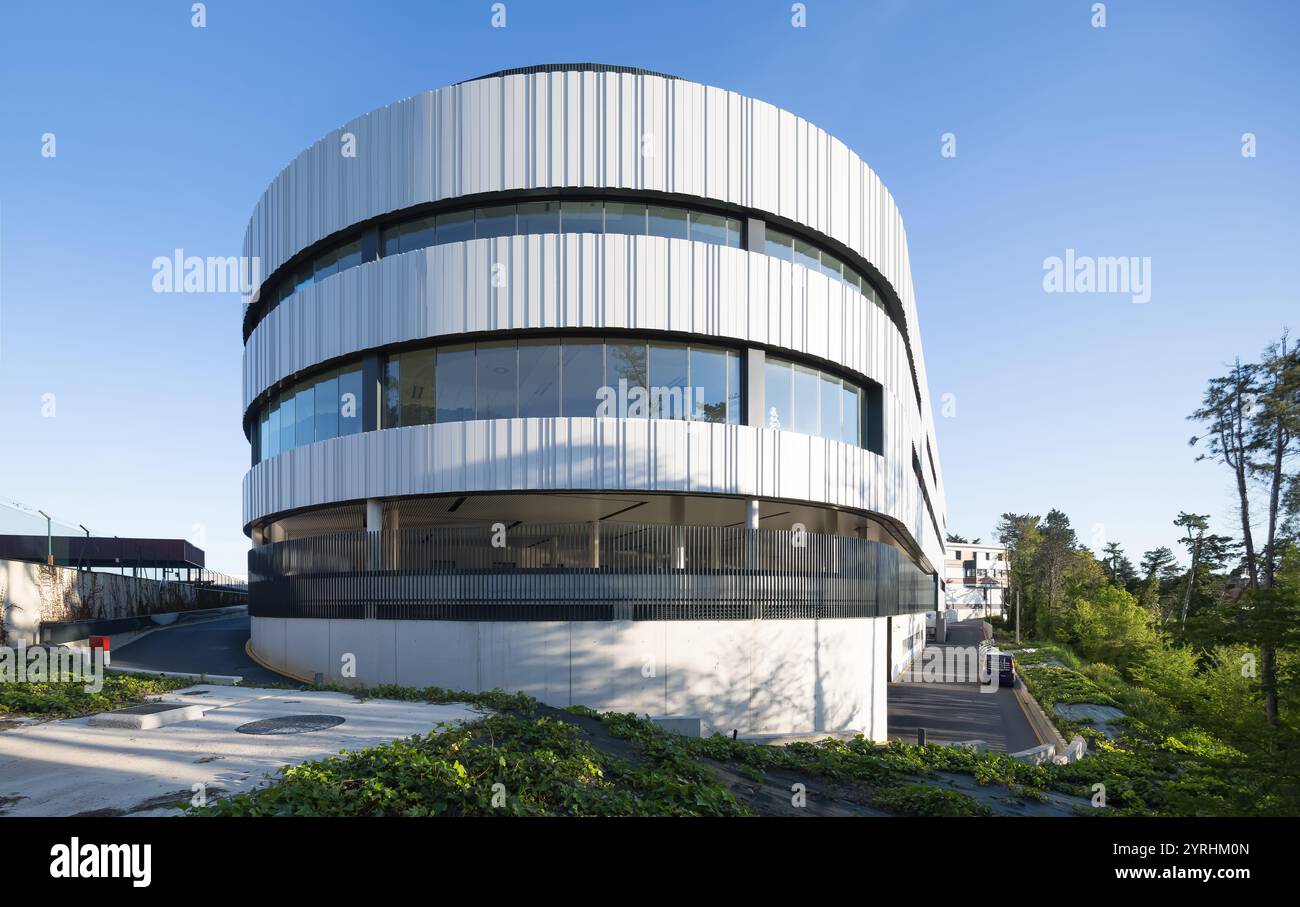 A modern hospital building showcasing a sleek, curved facade surrounded ...