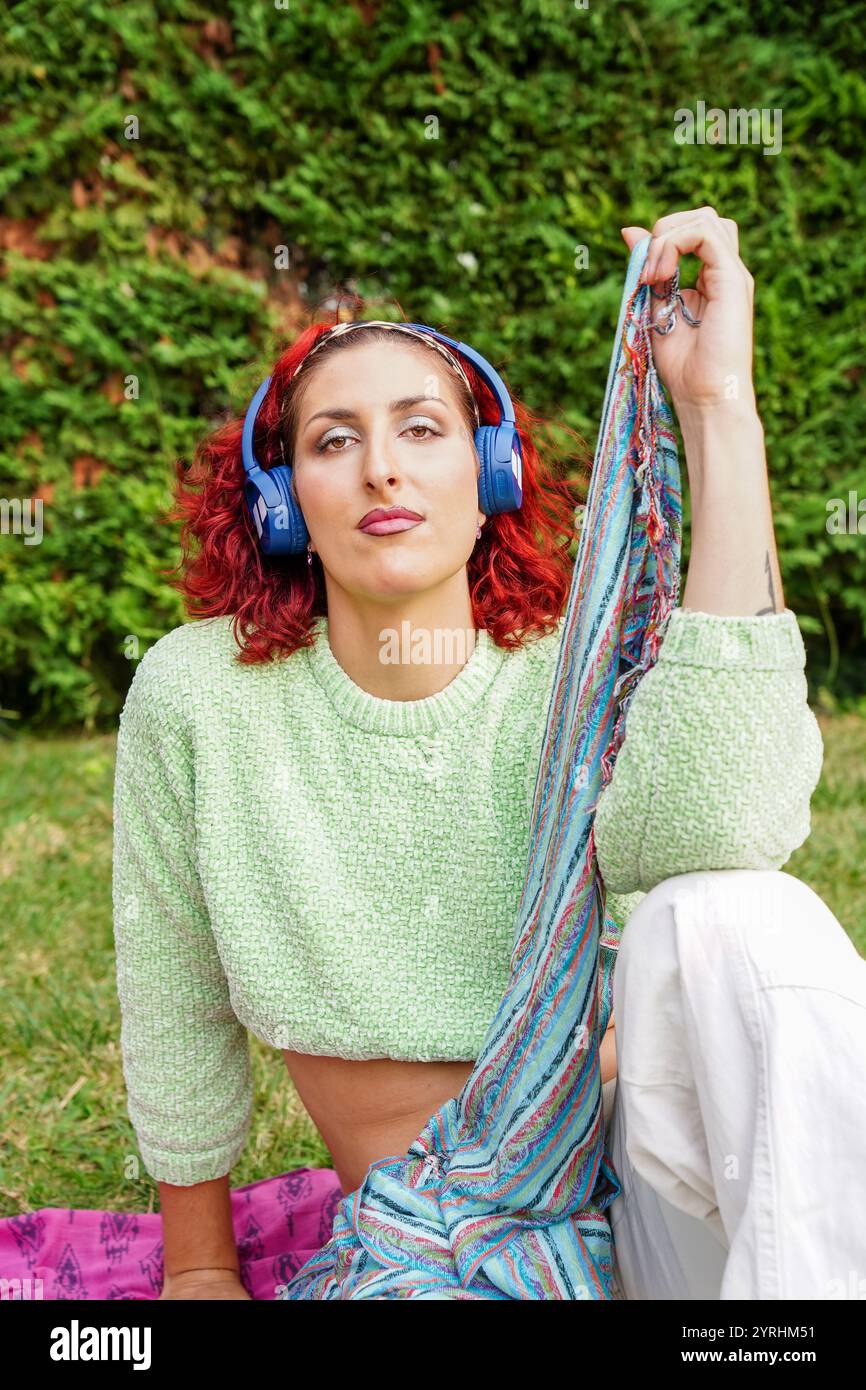 A trans woman with red hair and blue headphones embraces a colorful ...