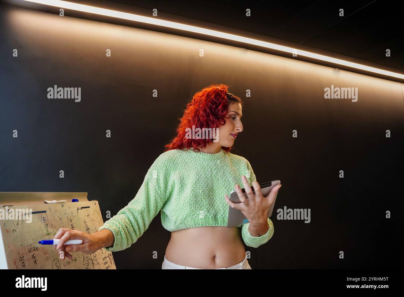 A trans woman confidently presents her ideas on a whiteboard, showing ...