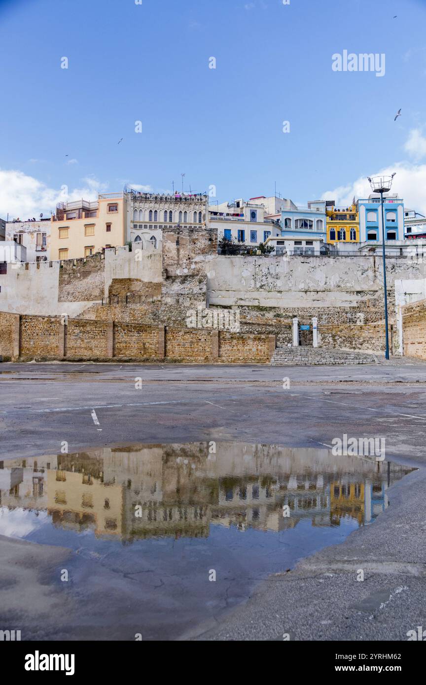 A captivating scene of colorful buildings atop a hillside, reflected in ...