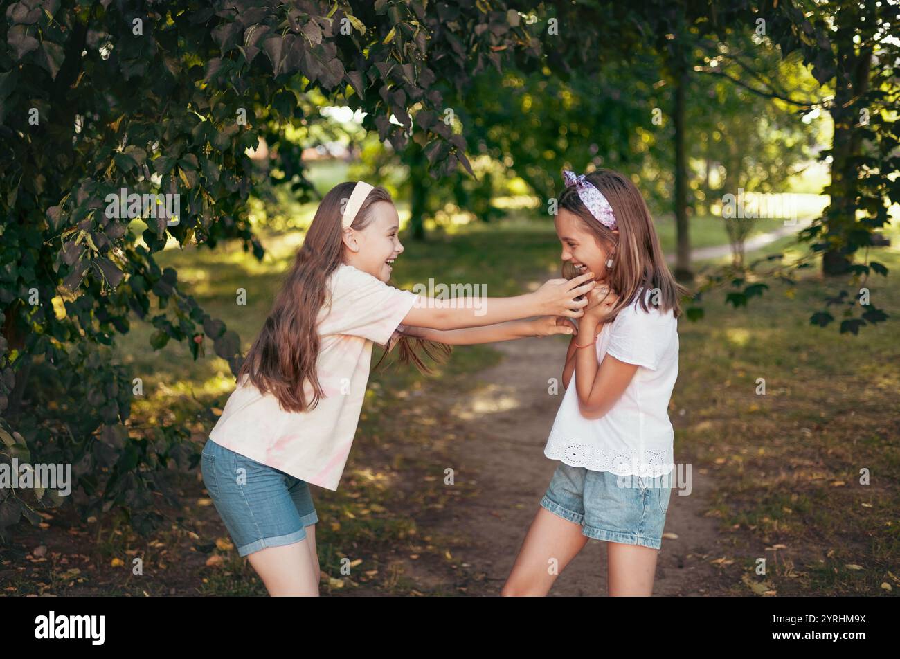 Cheerful girls play together and have fun in the park in summer ...