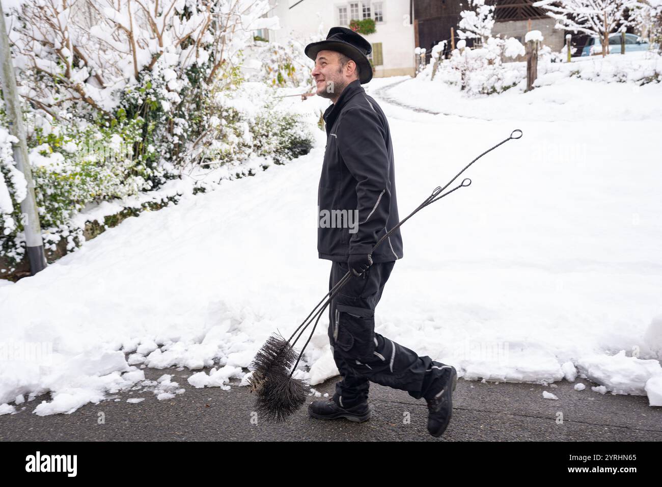 A chimney sweep walks through a snow-covered neighborhood, carrying ...