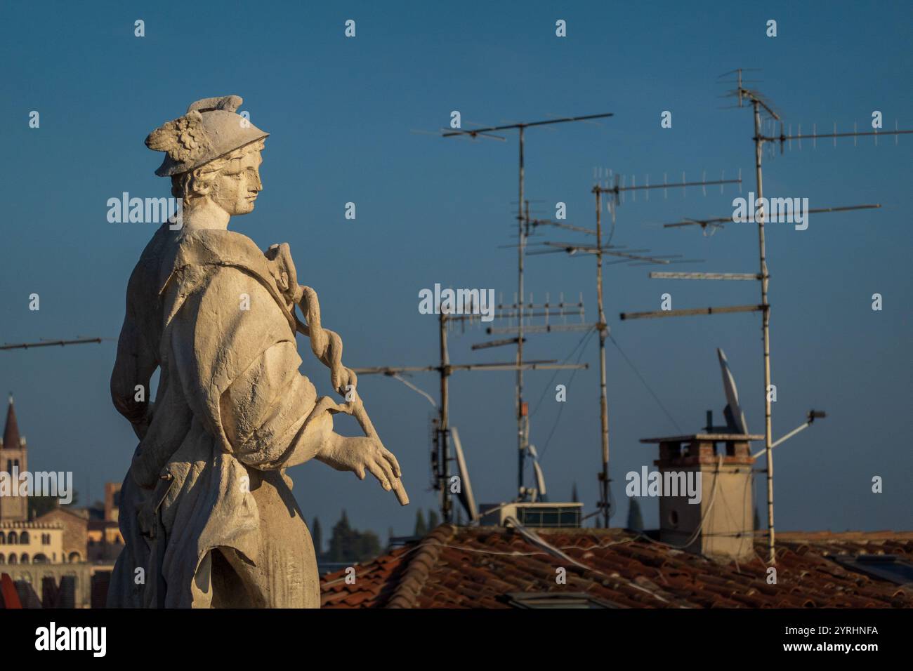 Statue of Roman god overlooks city rooftops with antennas, capturing ...