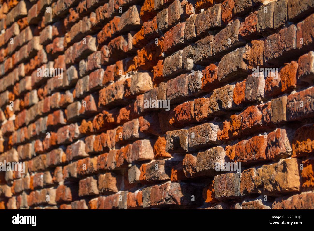 Detailed view of rugged red brick wall showing unique texture and warm ...