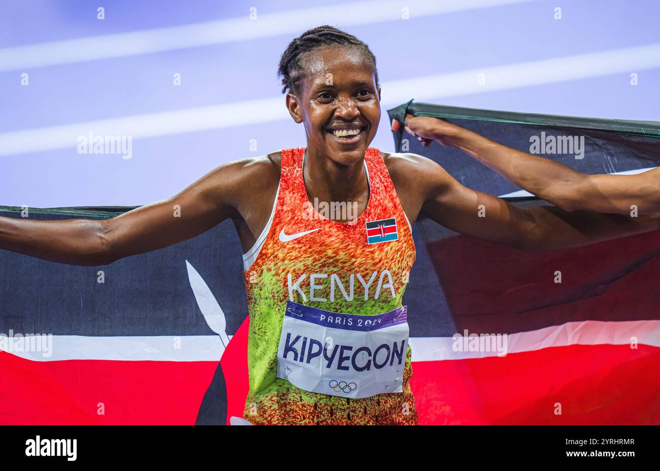 Faith Kipyegon celebrating her medal with her country's flag at the ...