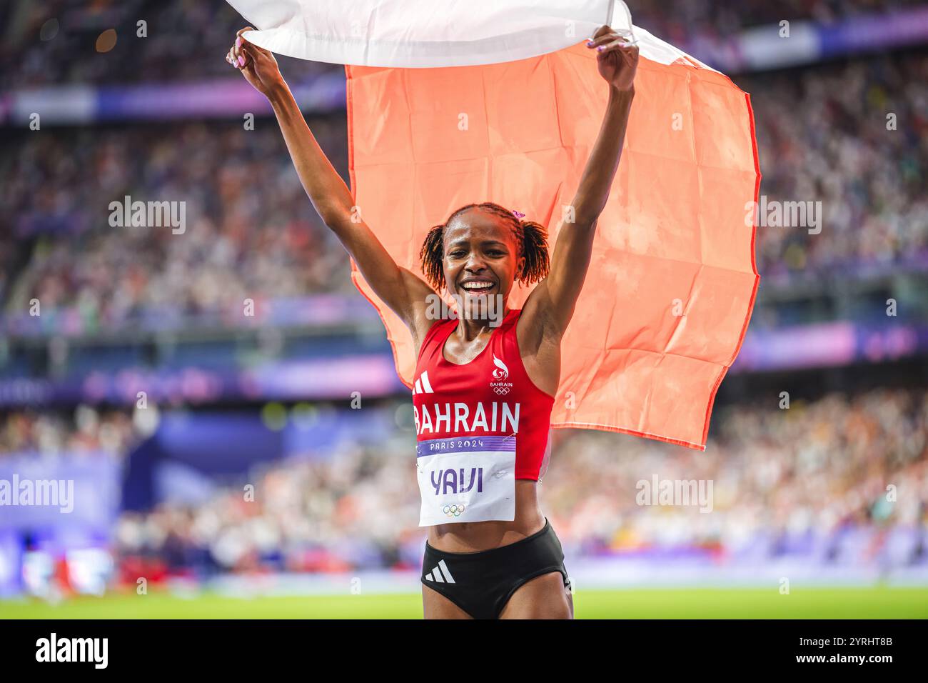 Winfred Yavi celebrating her medal with her country's flag at the Paris ...