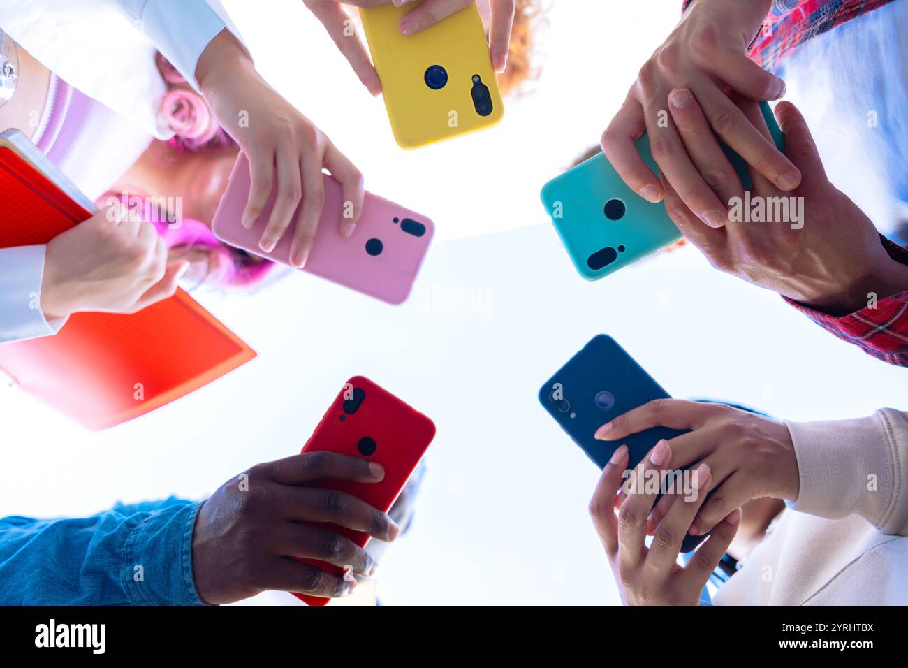 Group of friends holding different smartphones together, showing ...