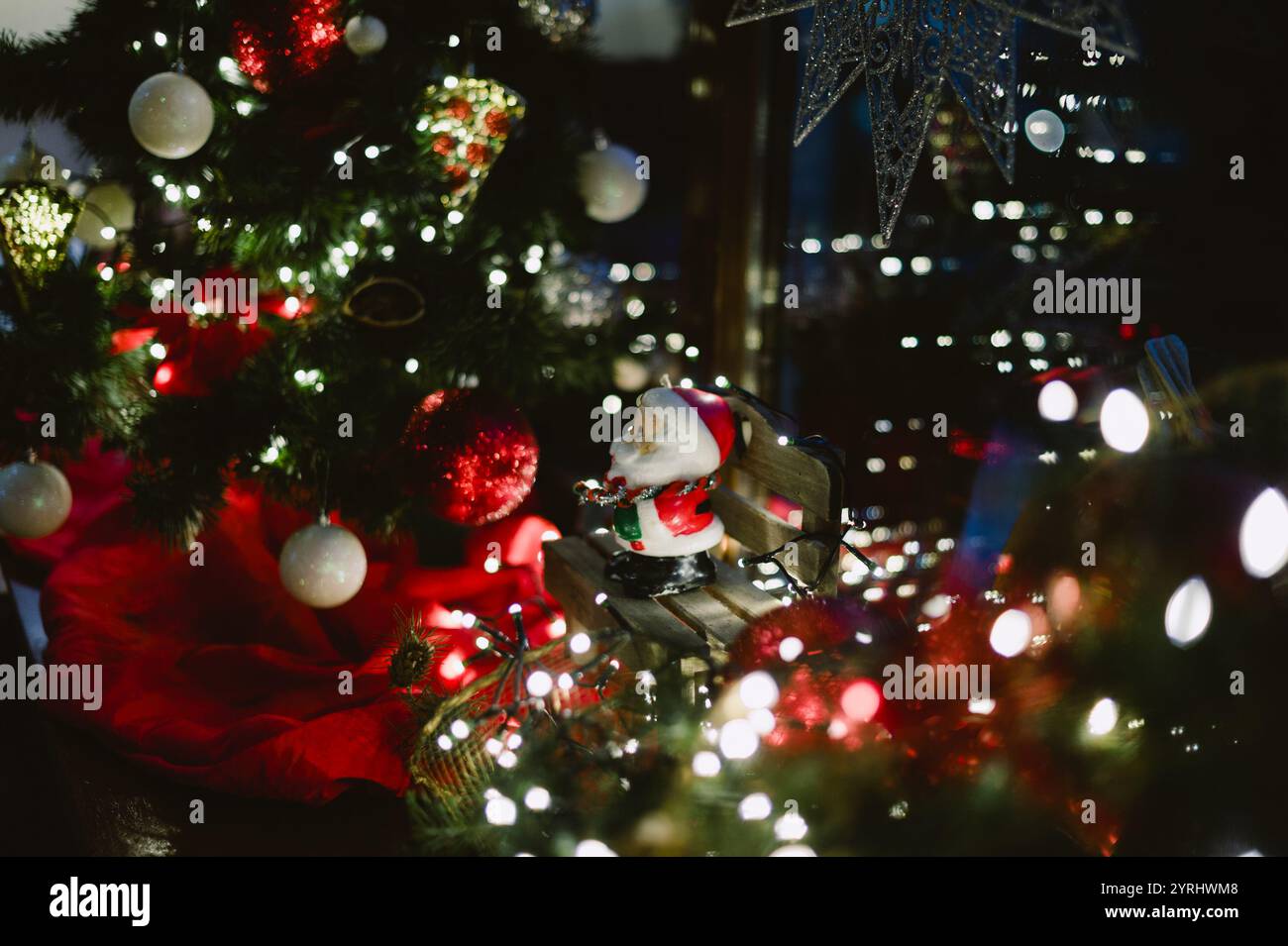 A christmas tree with a santa sitting on a bench. The bench is ...