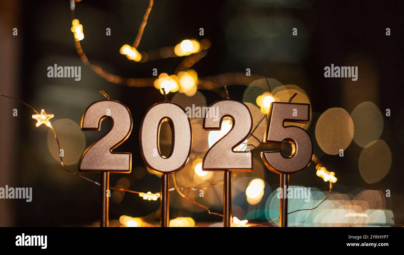 Happy new year 2025 with festive lights at night. Golden candles 2025 with bokeh stars lights ...