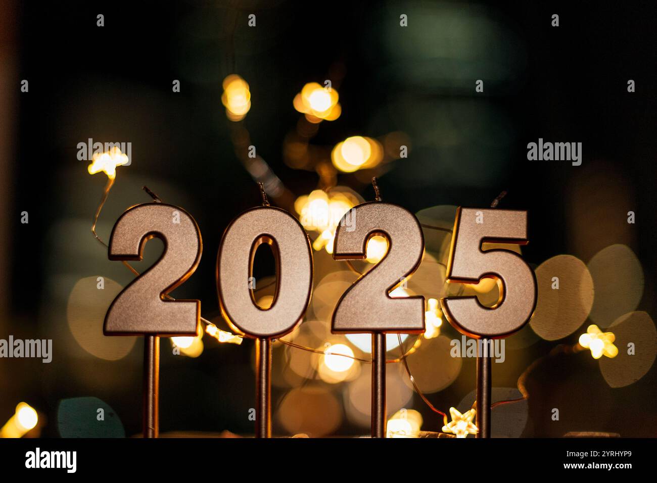 Golden candles festive 2025 at night with urban bokeh with lights stars. Happy New Year 2025 ...