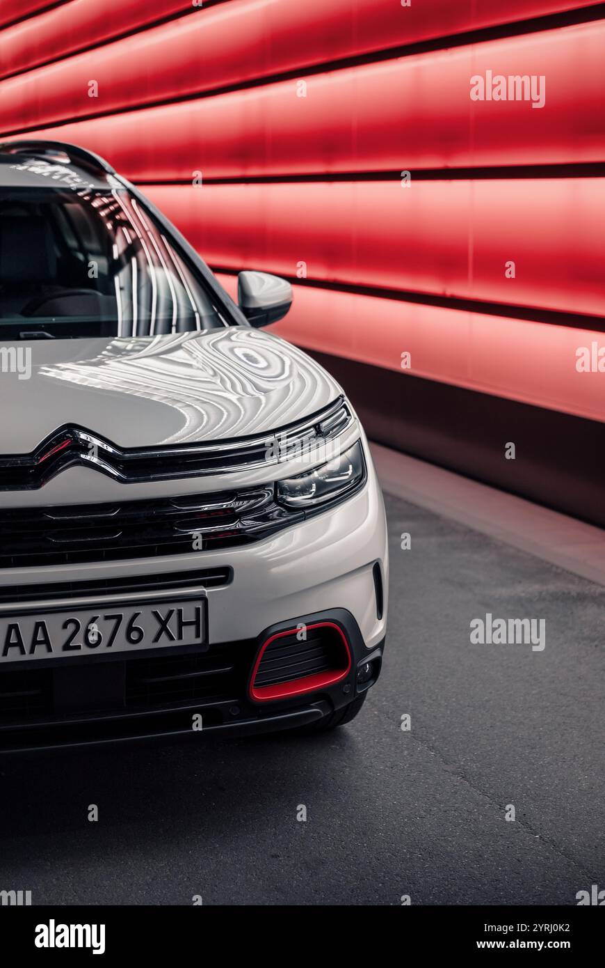 white Citroen C5 Aircross on a street with red glowing wall. Front ...