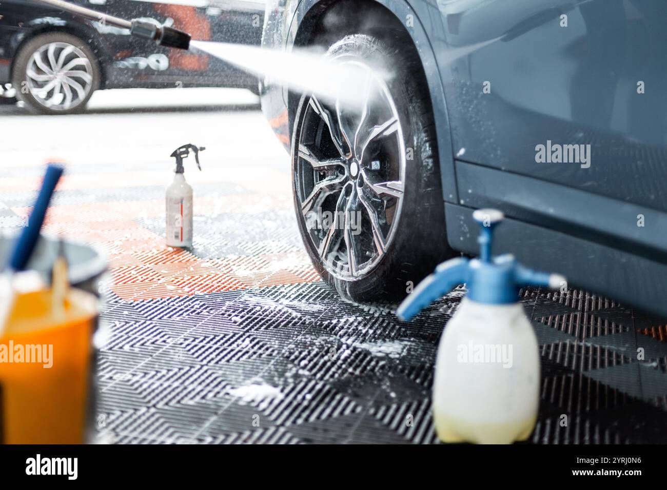 Professional man washes wheels and tires in the garage. Car wash and ...