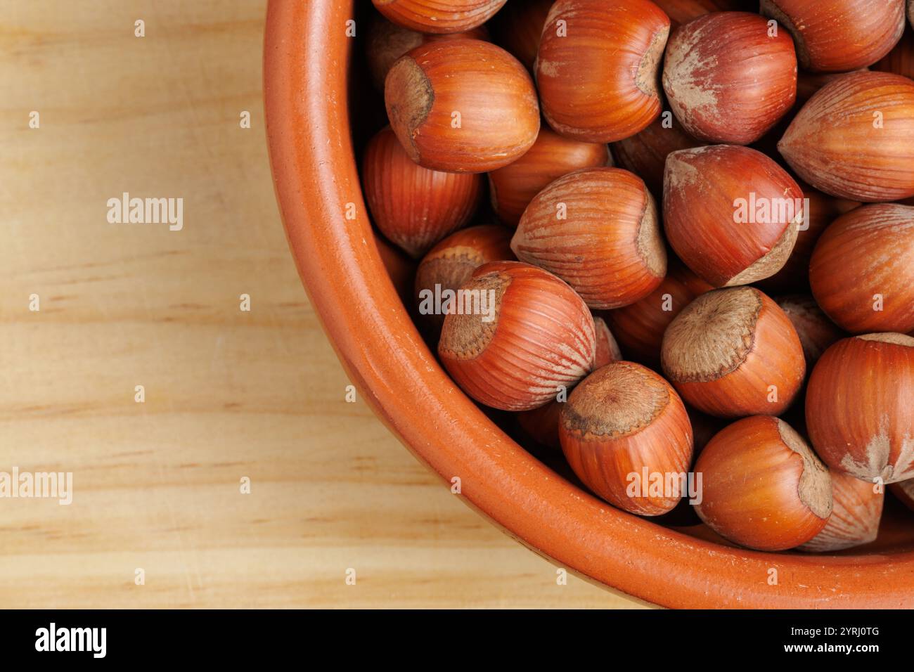 Group of hazelnuts with shell in a terracotta container on a kitchen ...