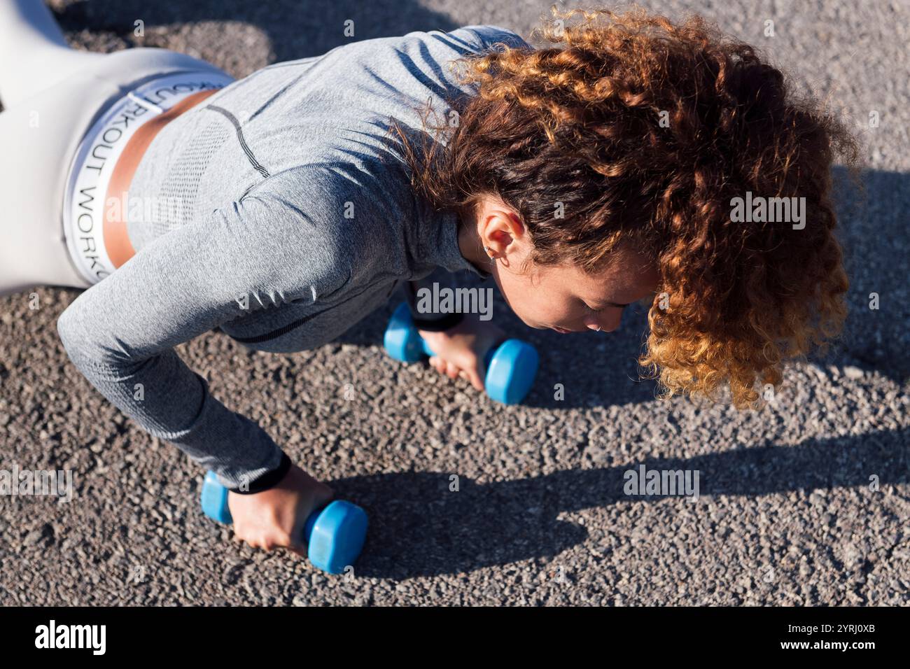 strong female athlete doing planks with dumbbells Stock Photo - Alamy