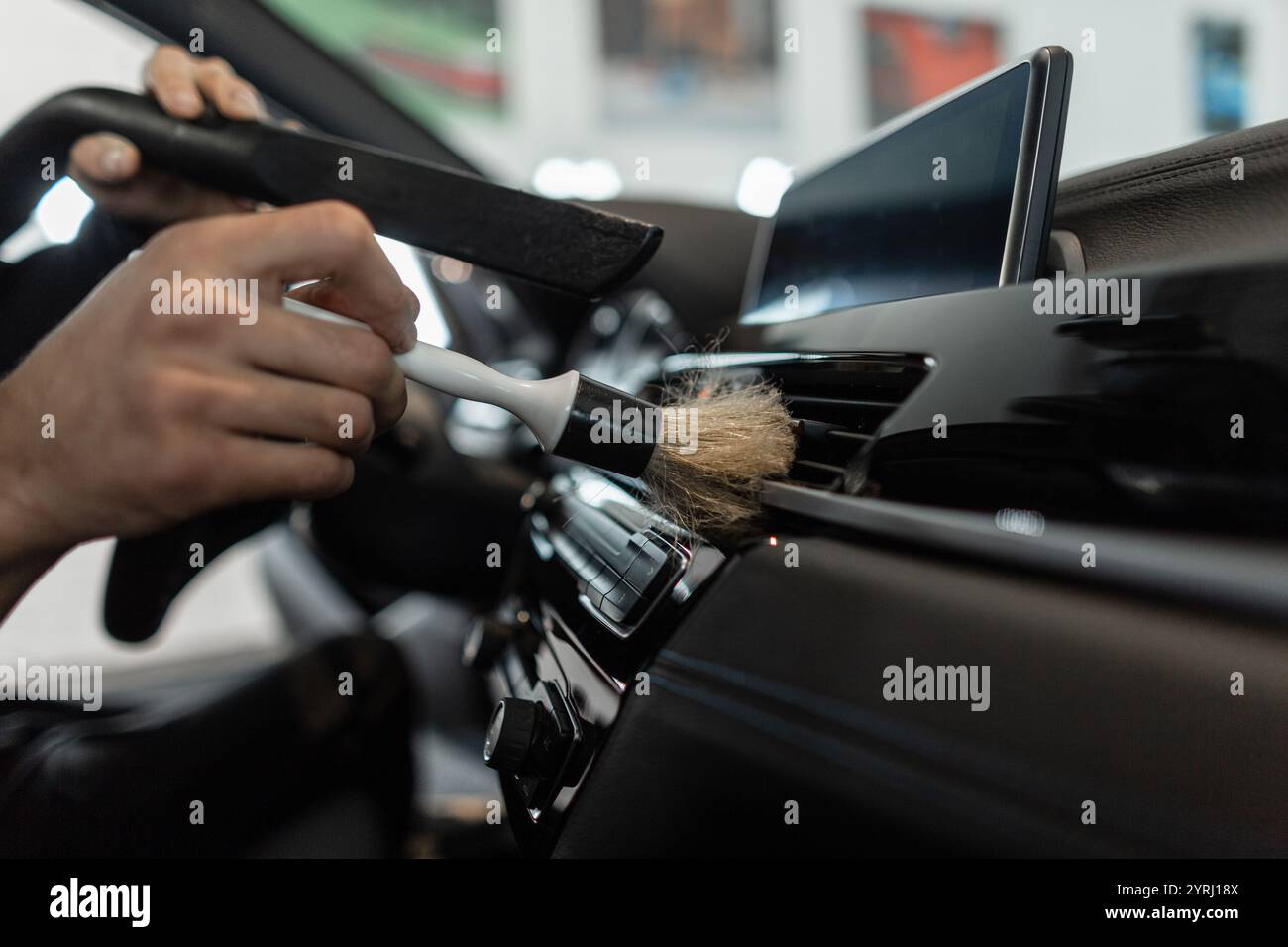 Professional man cleaning car dashboard with brush. Detailing Stock ...