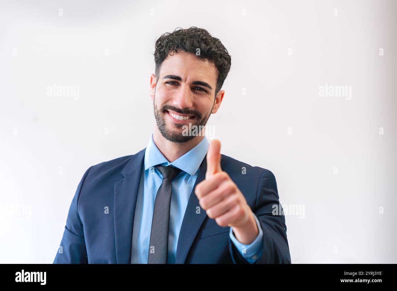 Confident businessman smiling and giving a thumbs-up gesture Stock ...