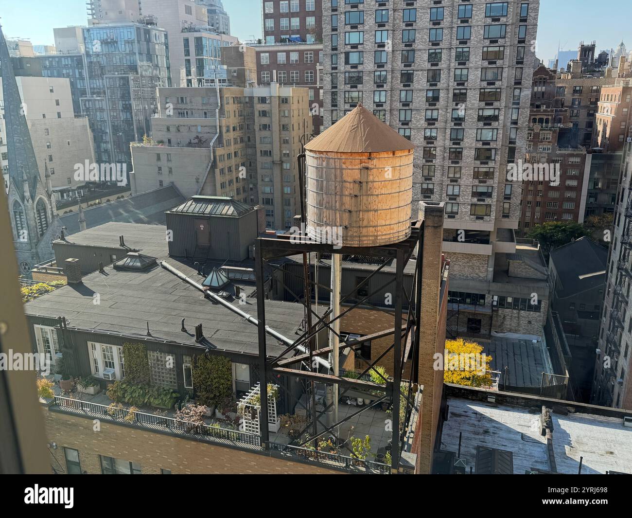 Typical NYC water tank elevated over the roof of the building it serves ...