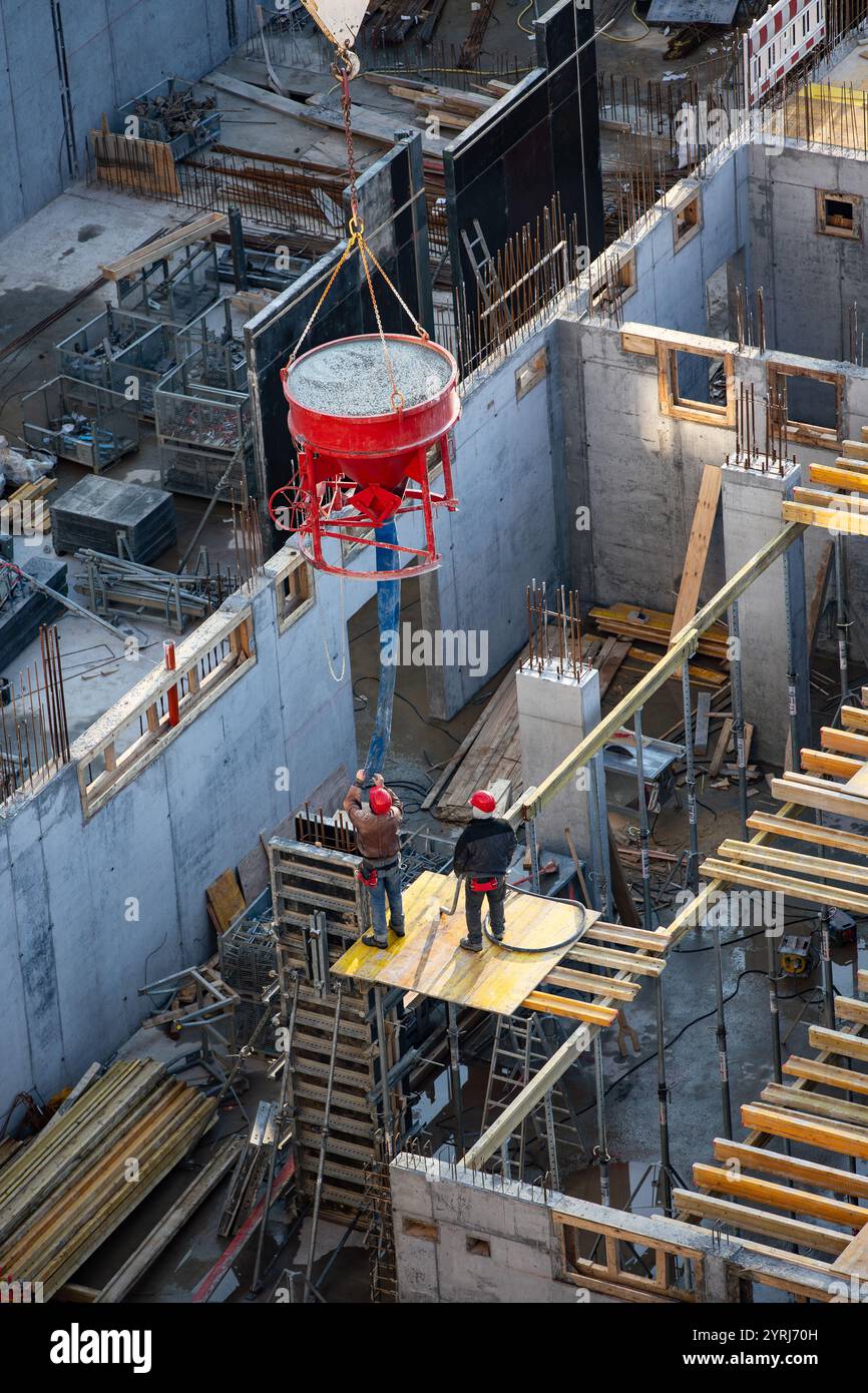Funnel with fresh concrete hovers over large construction site Stock ...