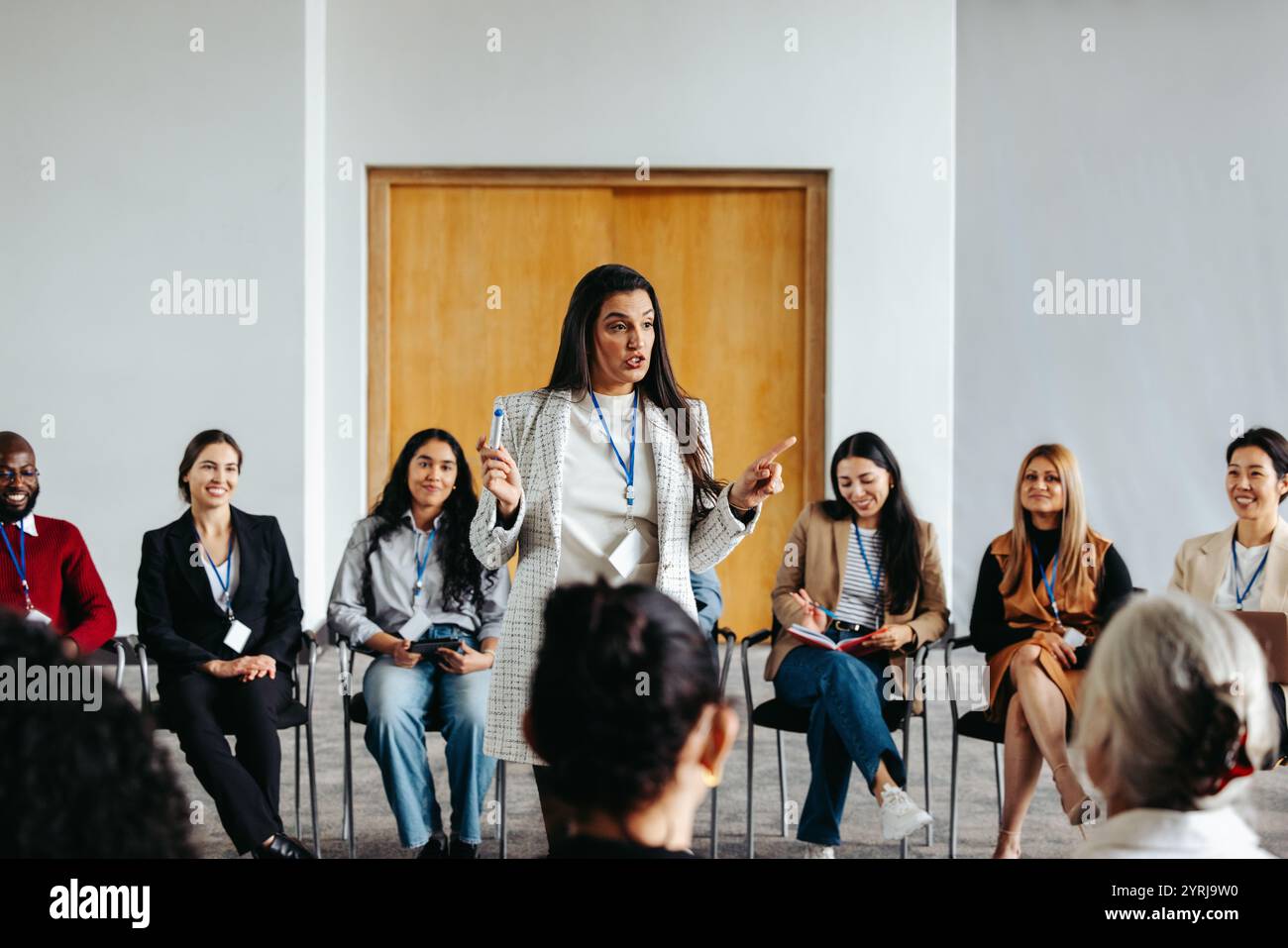 A female instructor is engaged in addressing a diverse group of people ...