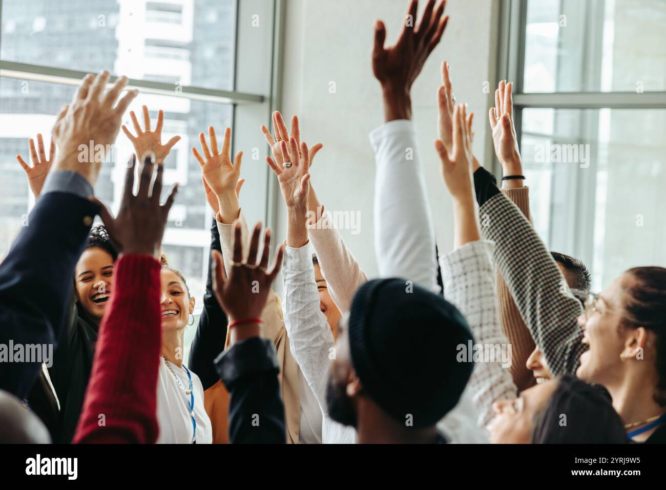 Team members with hands raised in unity, displaying engagement and ...