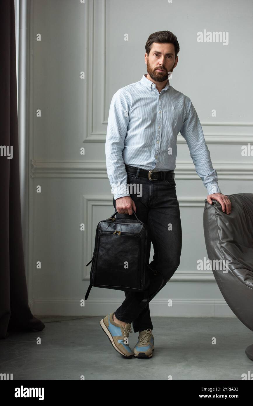 A Stylish and Professional Man Standing with a Bag in a Contemporary ...