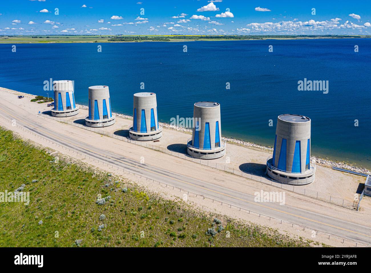 A group of four blue and white structures are on a beach near a body of ...