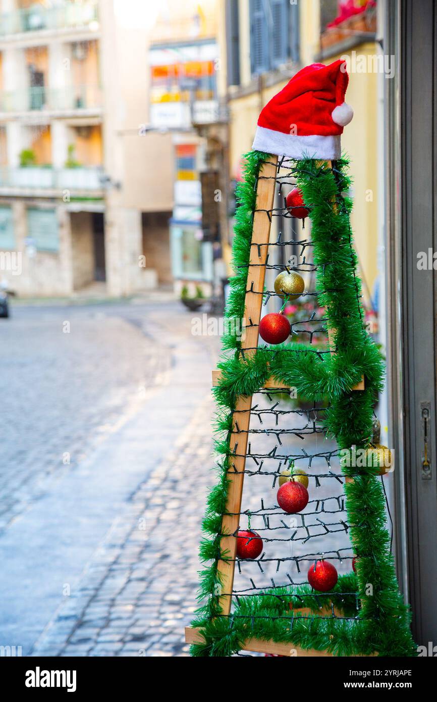 A beautifully adorned Christmas tree featuring a Santa hat placed on ...