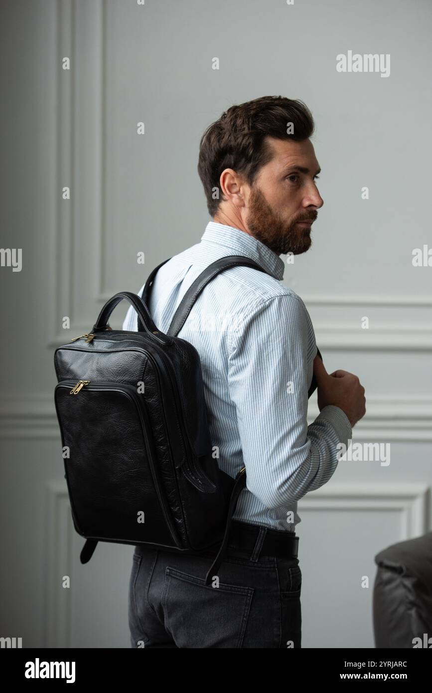A Stylish and Professional Man Standing with a Bag in a Contemporary ...